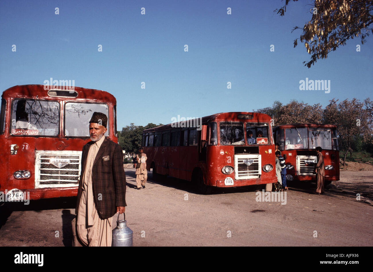 Pakistan Islamabad bus station man milk container and red busses C ...