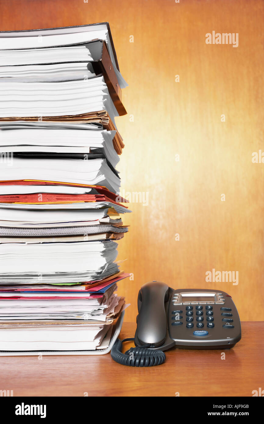 Stack of paperwork and telephone on desk Stock Photo - Alamy