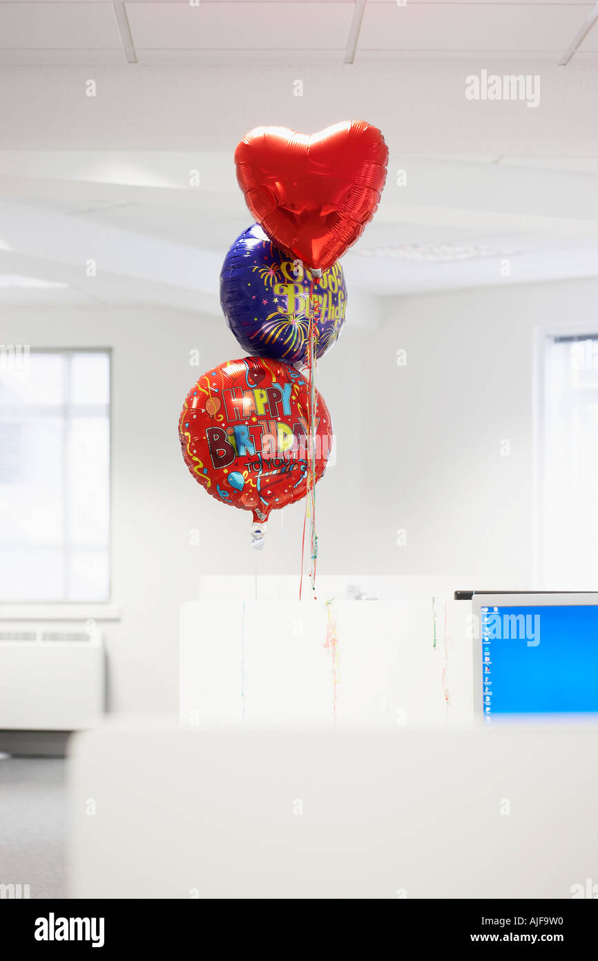 Colourful balloons hanging over office cubicle Stock Photo - Alamy