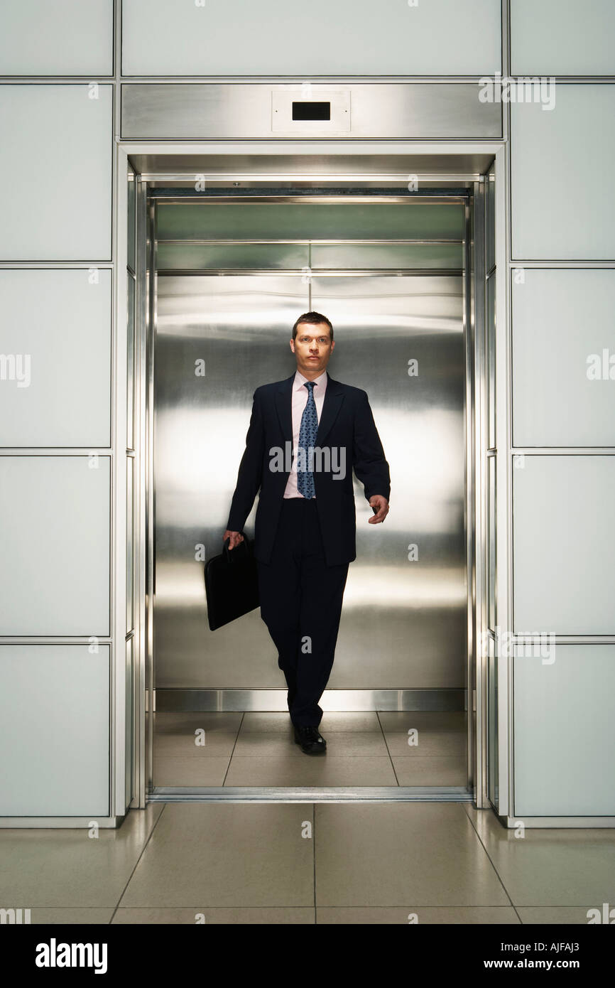 Businessman Exiting Elevator, front view Stock Photo - Alamy