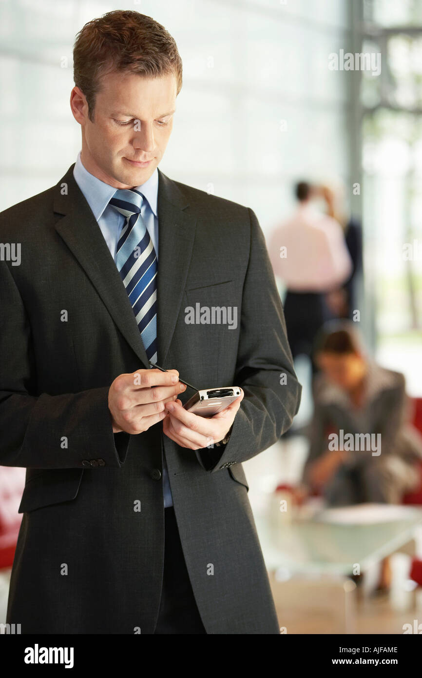 Businessman in Office Using PDA Stock Photo - Alamy