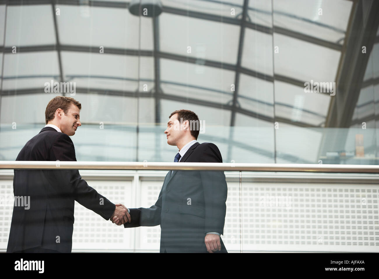 Two Businessmen Shaking Hands, side view Stock Photo - Alamy