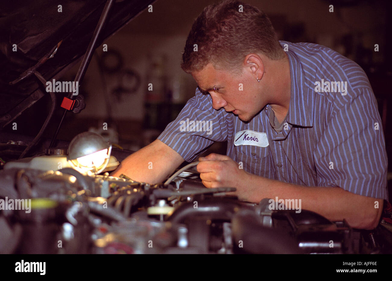 Mechanic working on car engine Stock Photo - Alamy