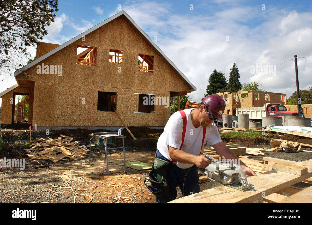 Construction worker cutting wood on the site of a housing development ...