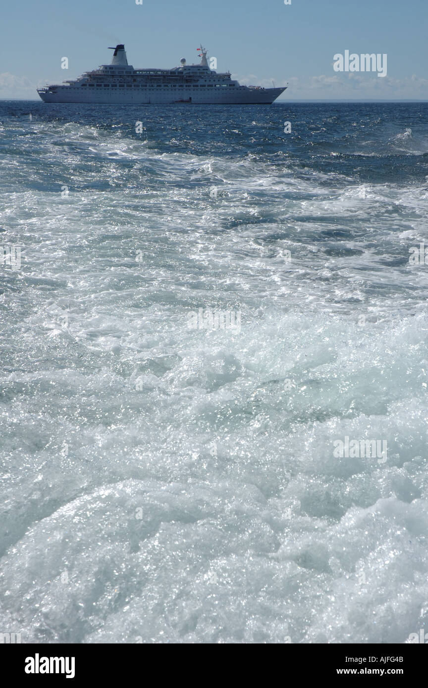Cruise ship Discovery with churned water from a tender boat on the way ...