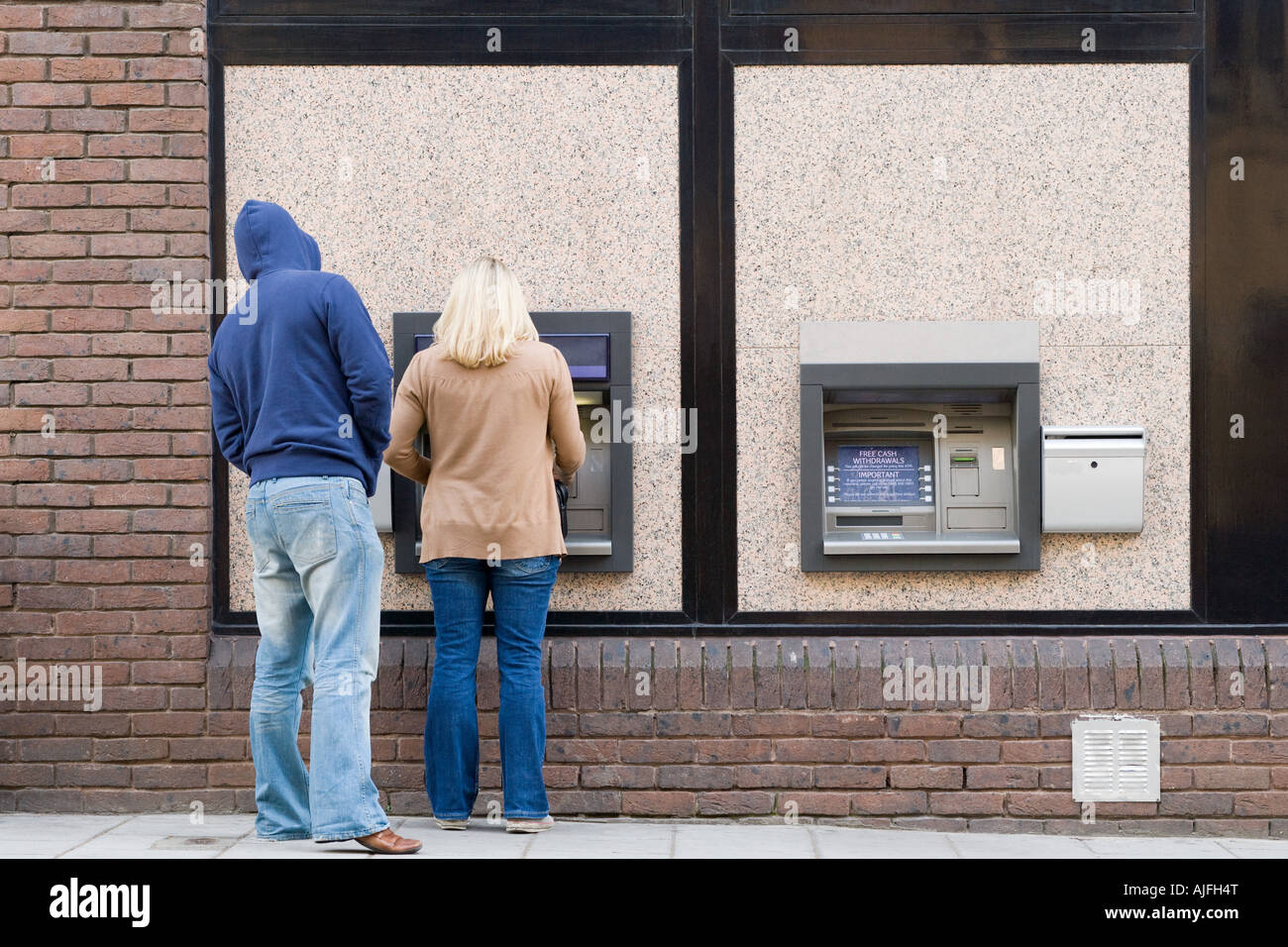 Thief looking over womans shoulder at cash machine Stock Photo - Alamy