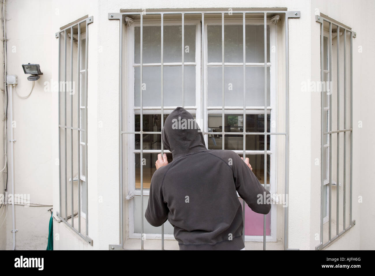 A thief looking through a window Stock Photo - Alamy