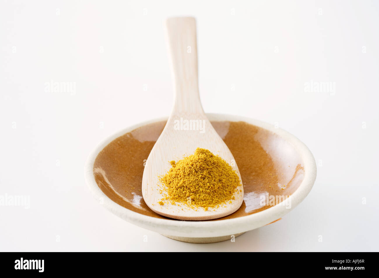 Curry powder wooden spoon and bowl Stock Photo - Alamy