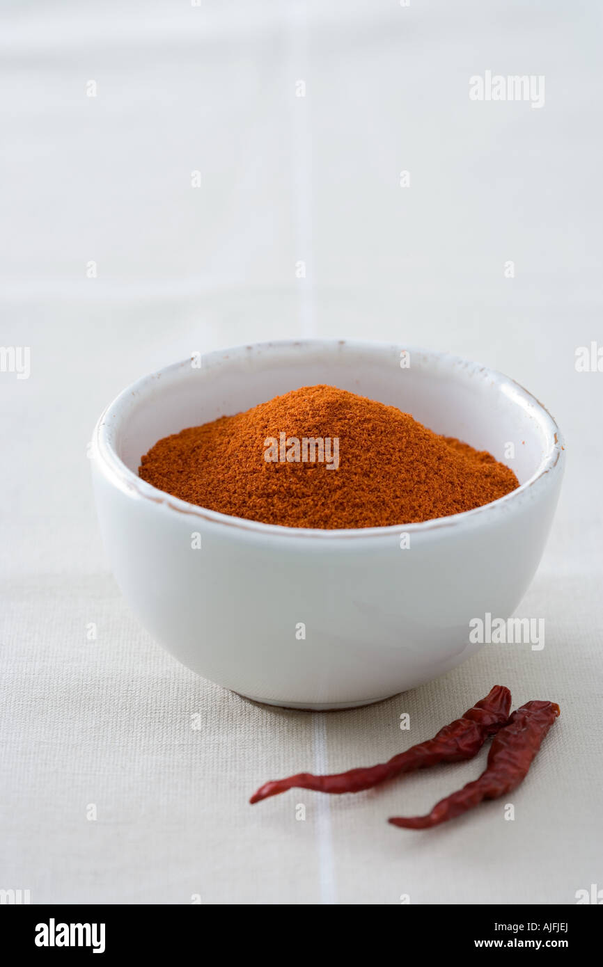 Bowl of chilli powder and chilli peppers Stock Photo - Alamy