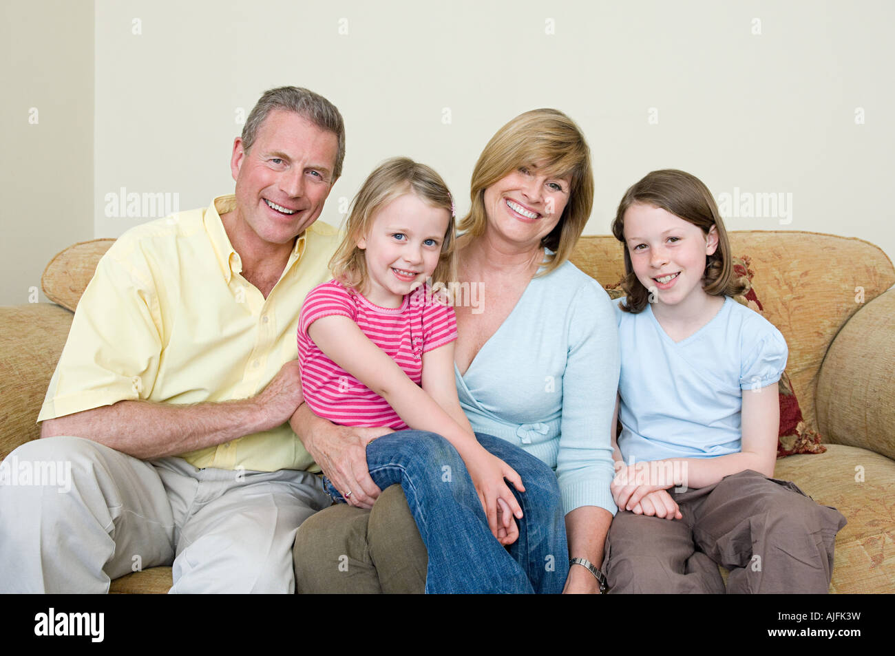 Family sitting on a sofa Stock Photo - Alamy