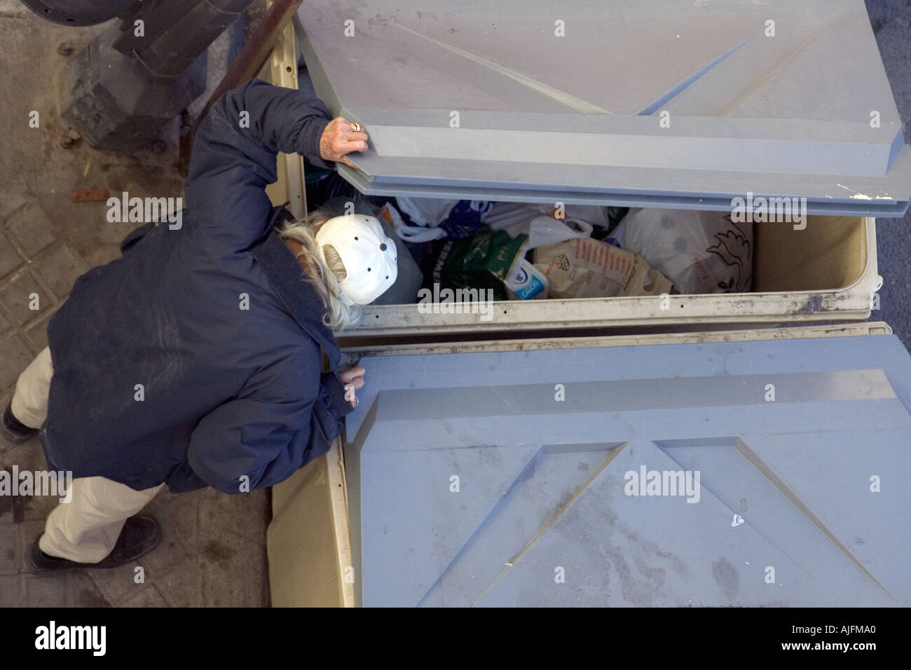 Homeless man rummaging garbage Stock Photo - Alamy
