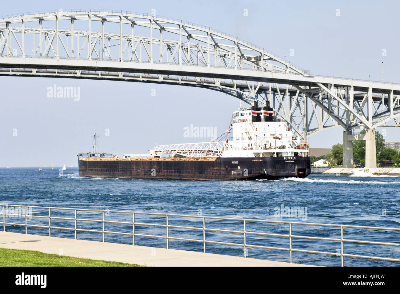 A lake freighter steams under the Blue Water Bridge Port Huron Michigan ...