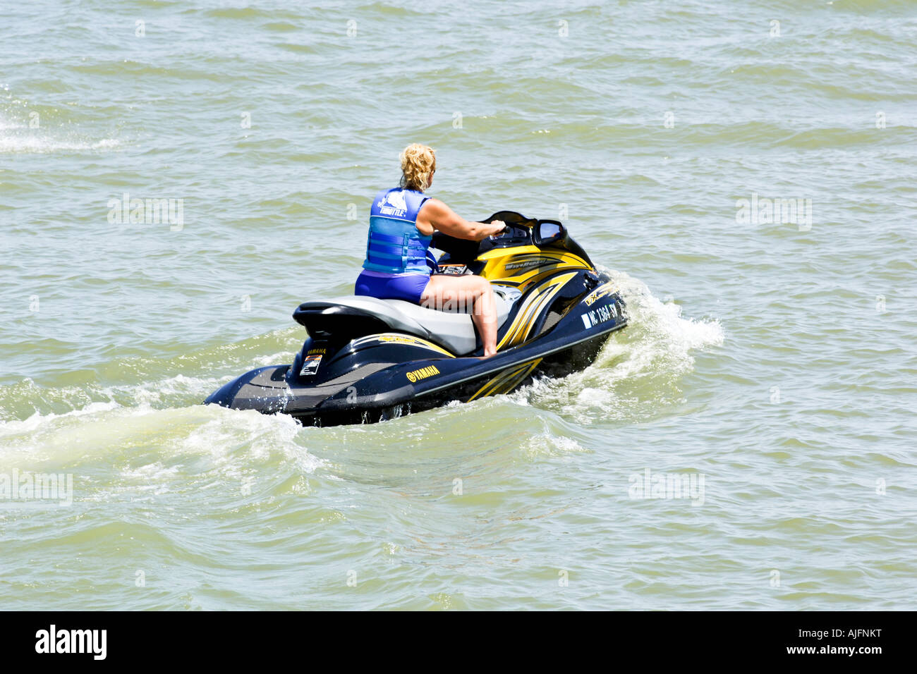 Adult Female riding a large jetski Stock Photo - Alamy