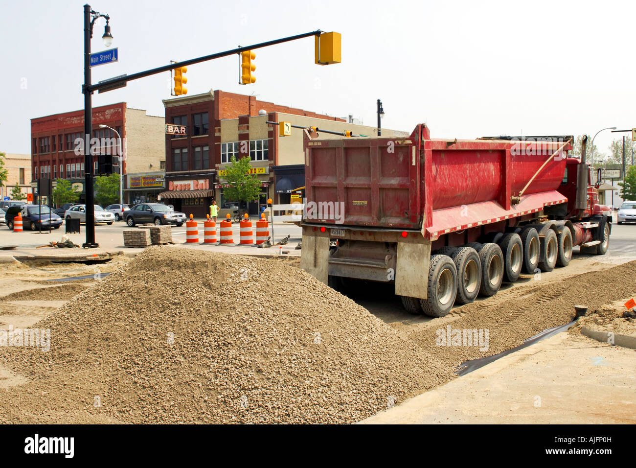 A large tipper truck unloads sand at a repaving project in downtown ...