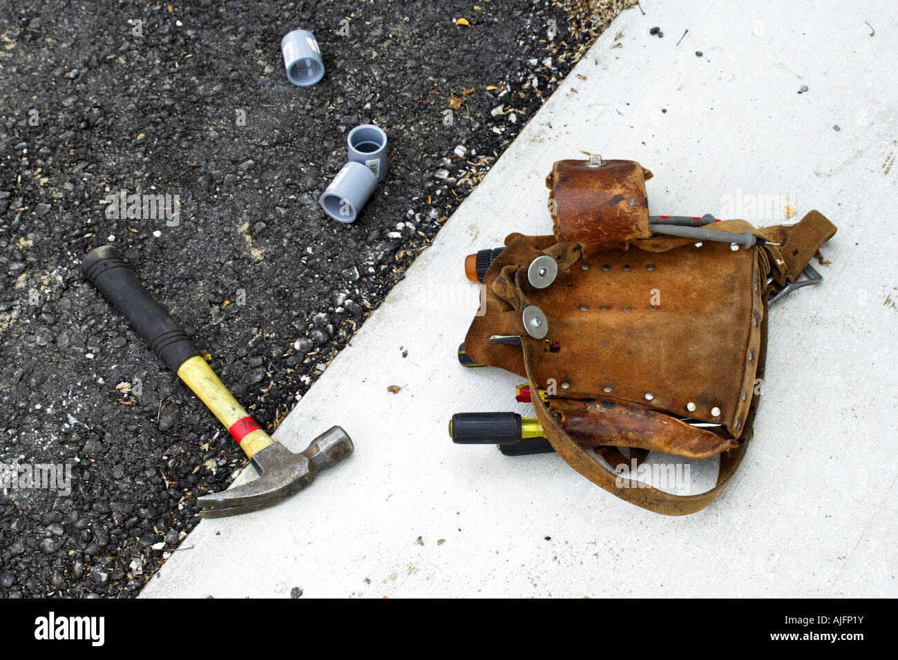 A Workmans tool belt and hammer Stock Photo - Alamy