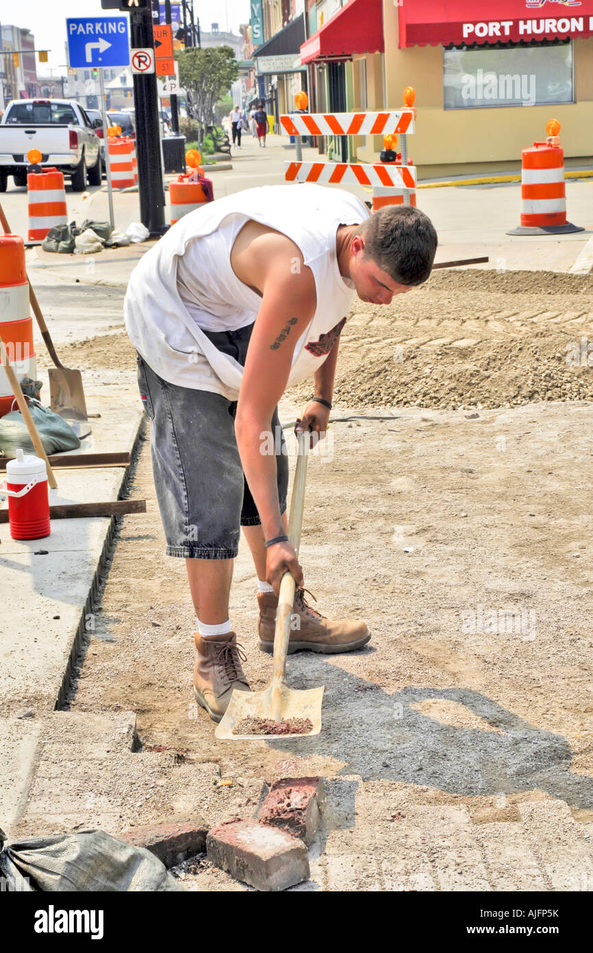 Construction worker removes road blocking for recycling at a ...