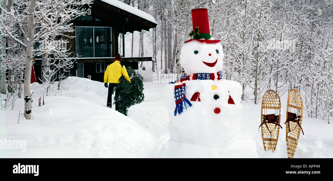 Bringing home the Christmas tree with jaunty snowman keeping an eye on ...