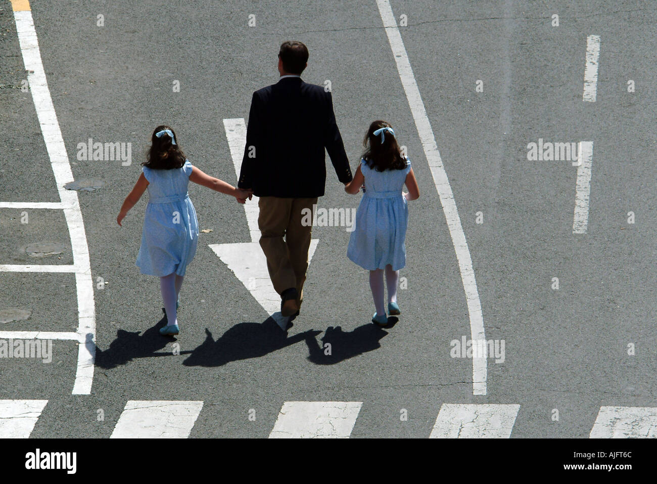 Father and two daughters by hand on a zebra crossing Stock Photo - Alamy