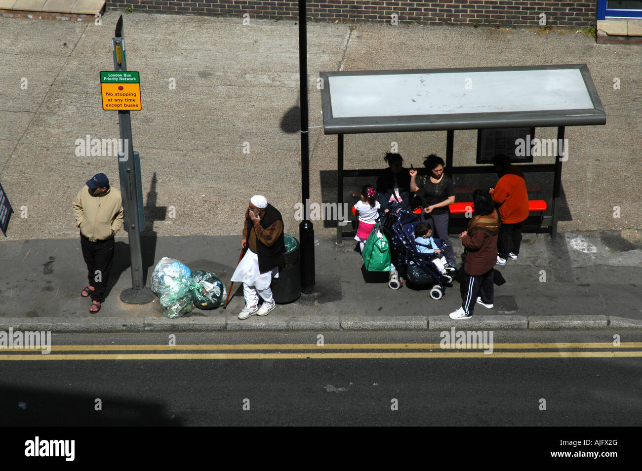 Hackney London UK Waiting at the bus stop Stock Photo - Alamy