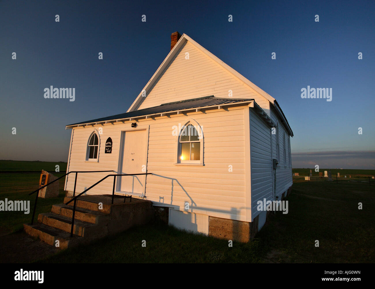Setting sun reflected in country church window Stock Photo - Alamy