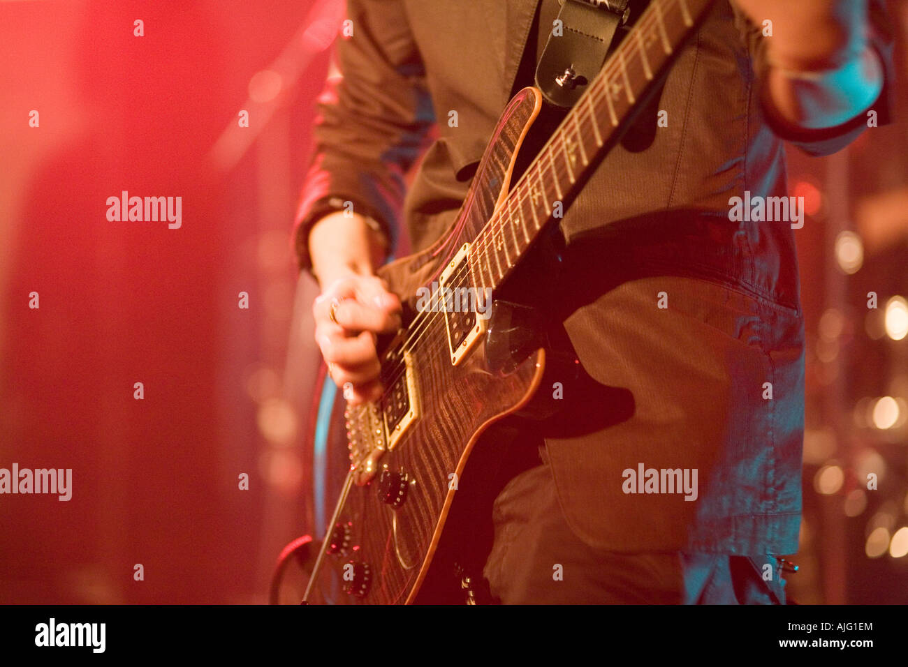 Young man playing electric guitar on stage Stock Photo - Alamy