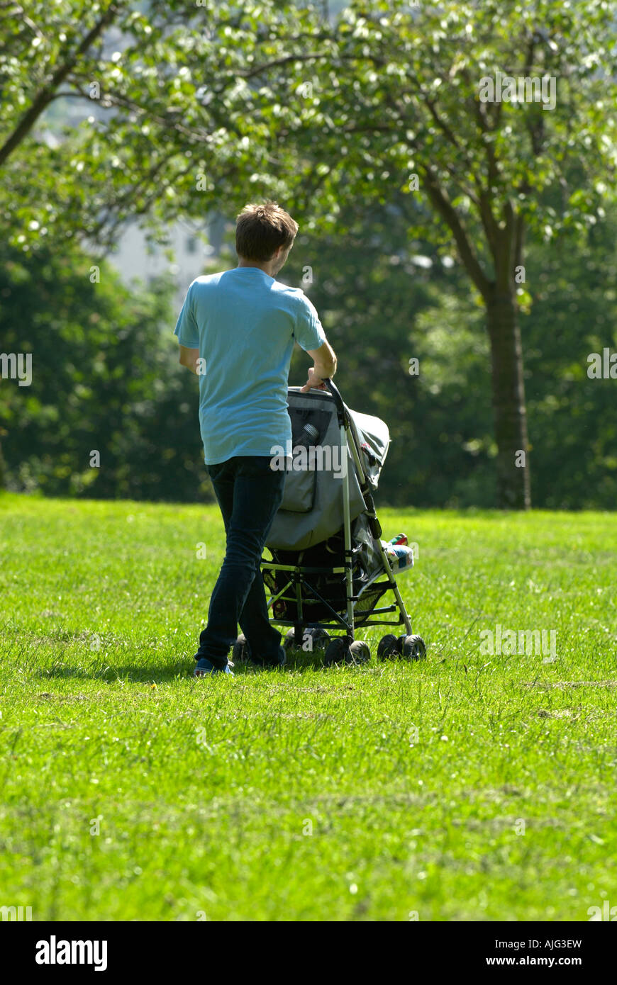 Man pushing a push chair in the sun Stock Photo - Alamy