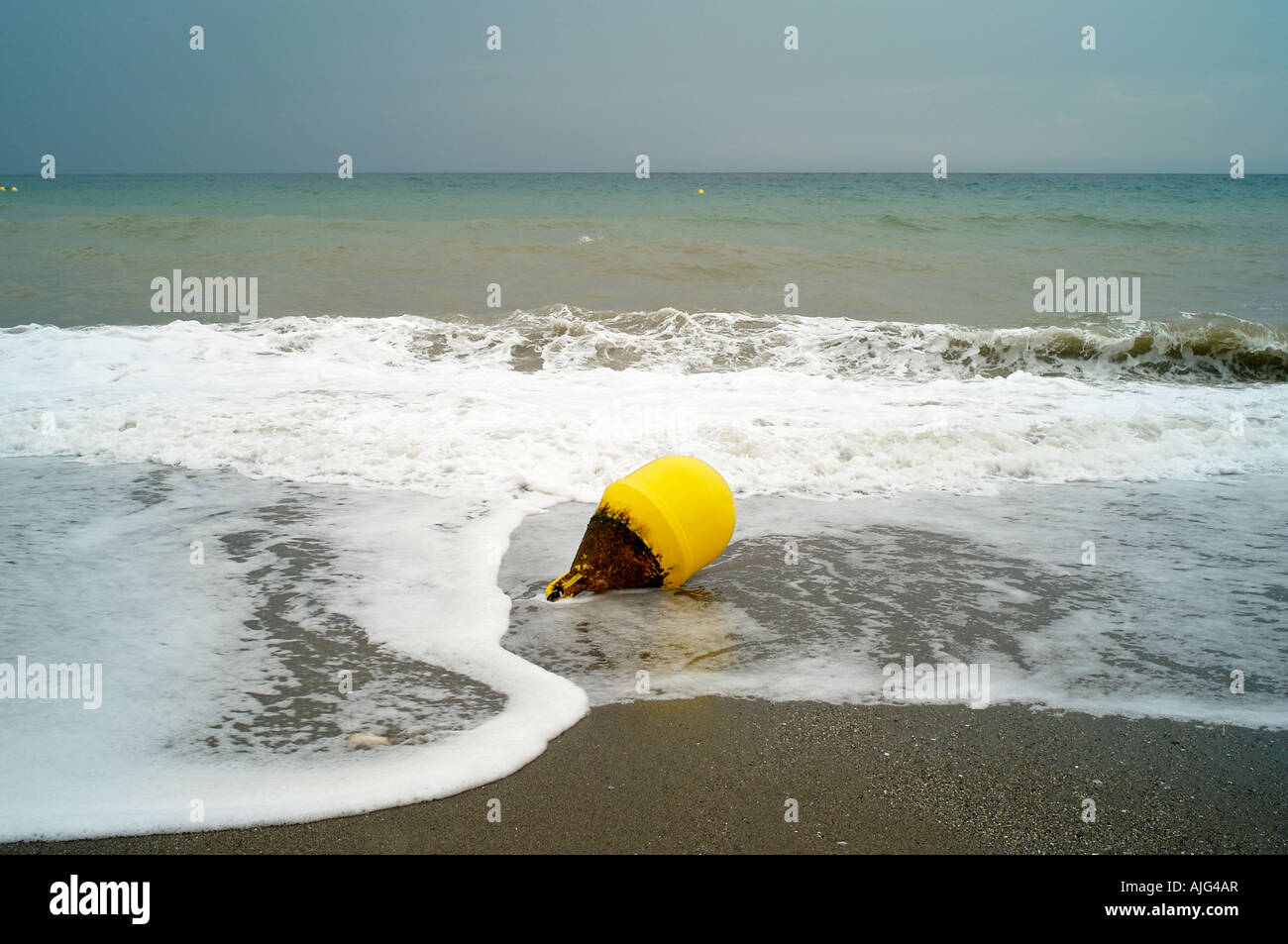 A yellow buoy washed up onto a beach Stock Photo - Alamy