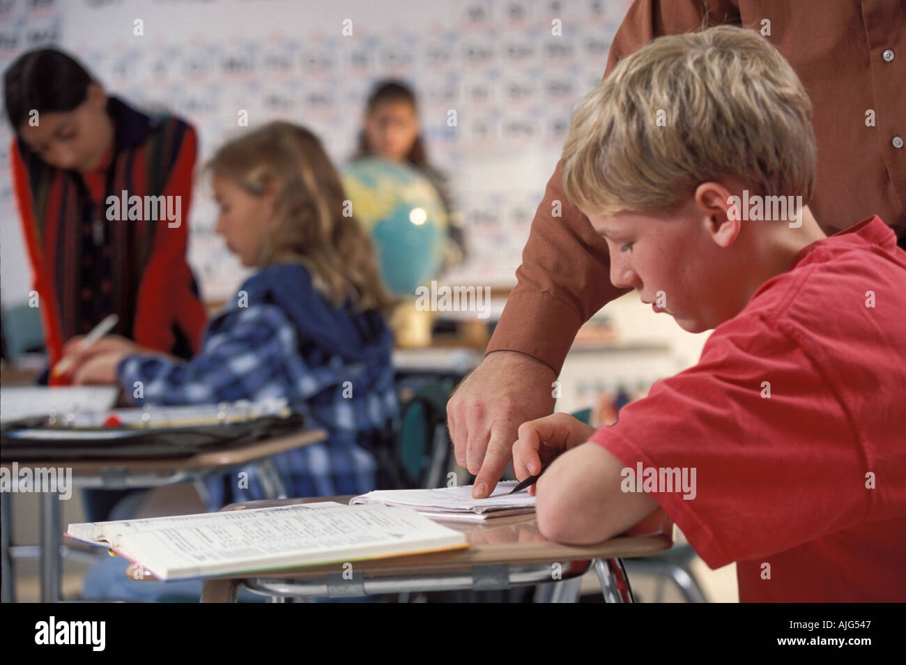 Caucasian male teacher helping middle school student in class Stock ...