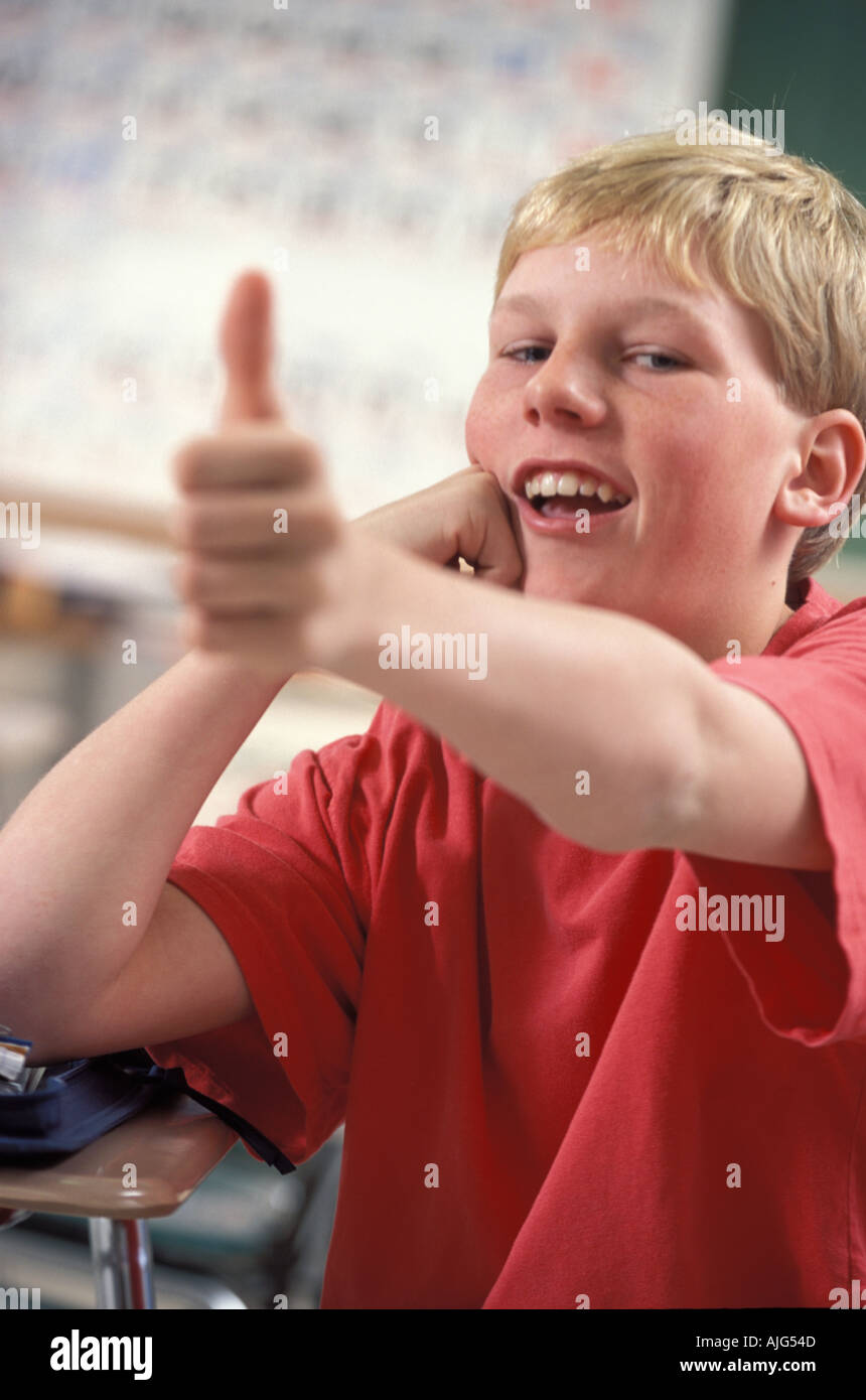Caucasian male student giving thumbs up in middle school class Stock ...