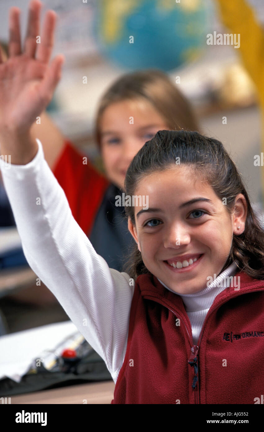 Caucasian female student raising hand in middle school class Stock ...
