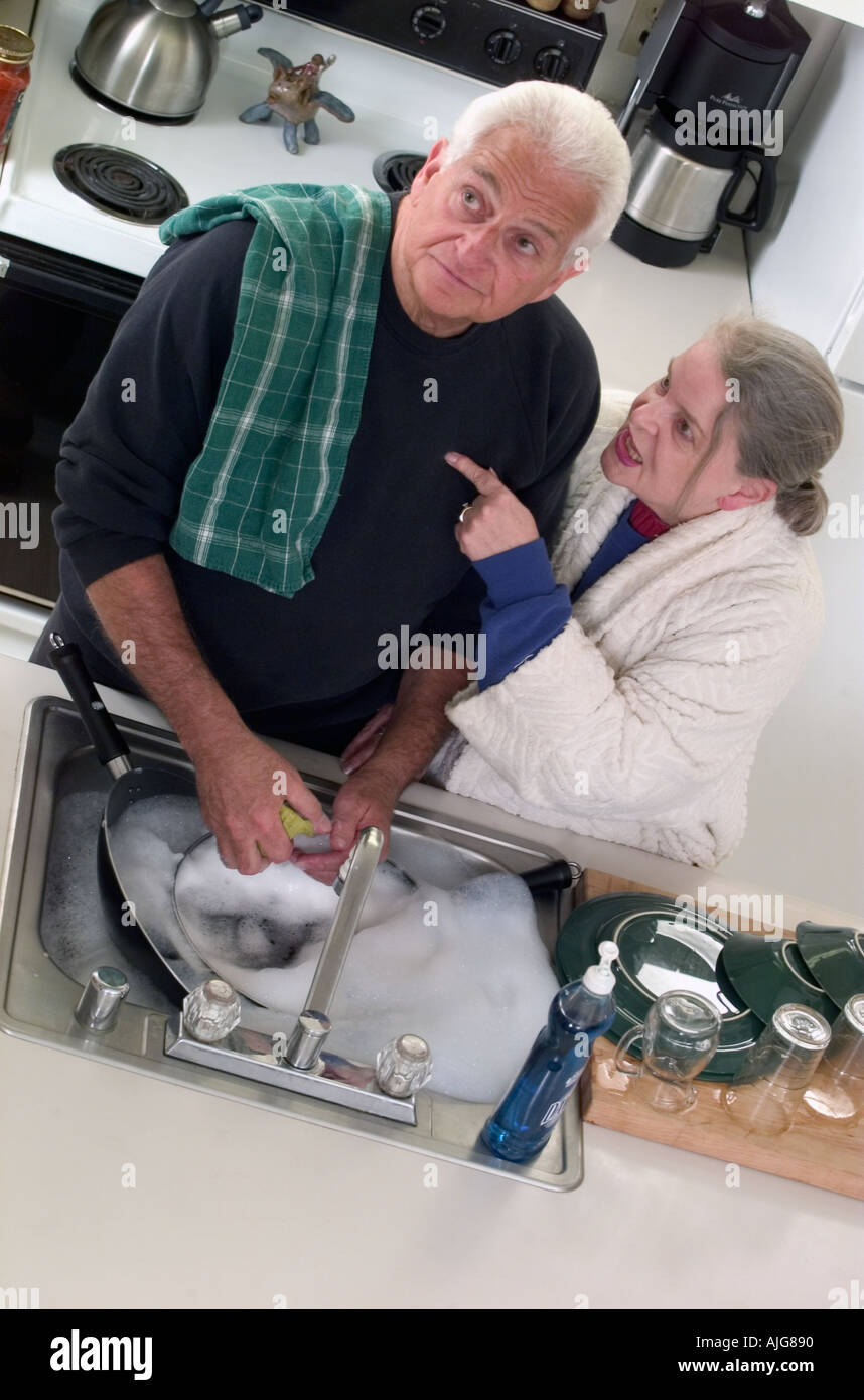 Caucasian senior wife yelling at husband doing the dishes Stock Photo ...