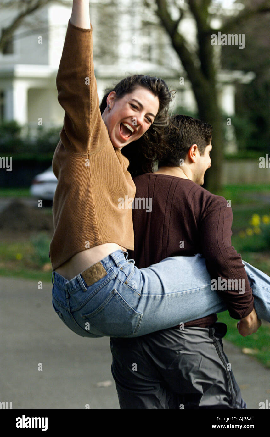Caucasian man giving girlfriend piggyback ride in park Stock Photo - Alamy