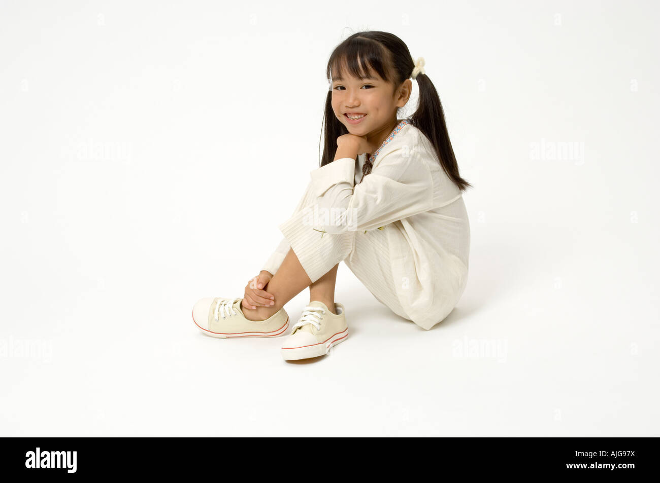 Elementary age girl sitting Stock Photo - Alamy