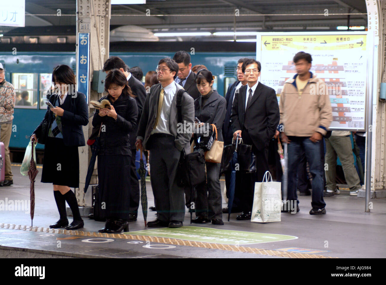 People waiting in a queue on a railway platform Osaka Japan Stock Photo ...