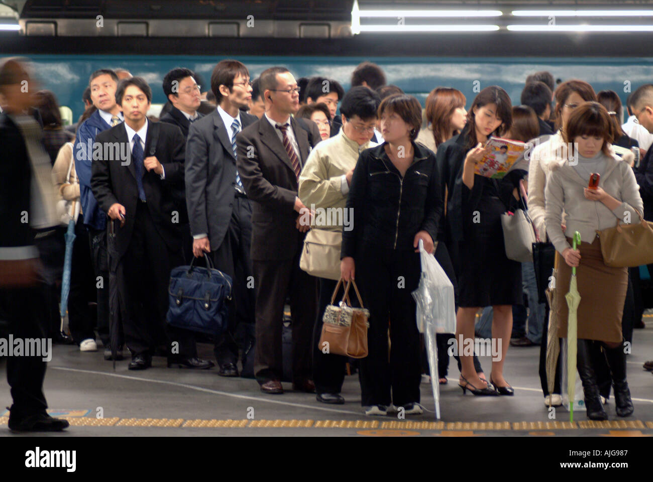 People waiting in a queue on a railway platform Osaka Japan Stock Photo ...