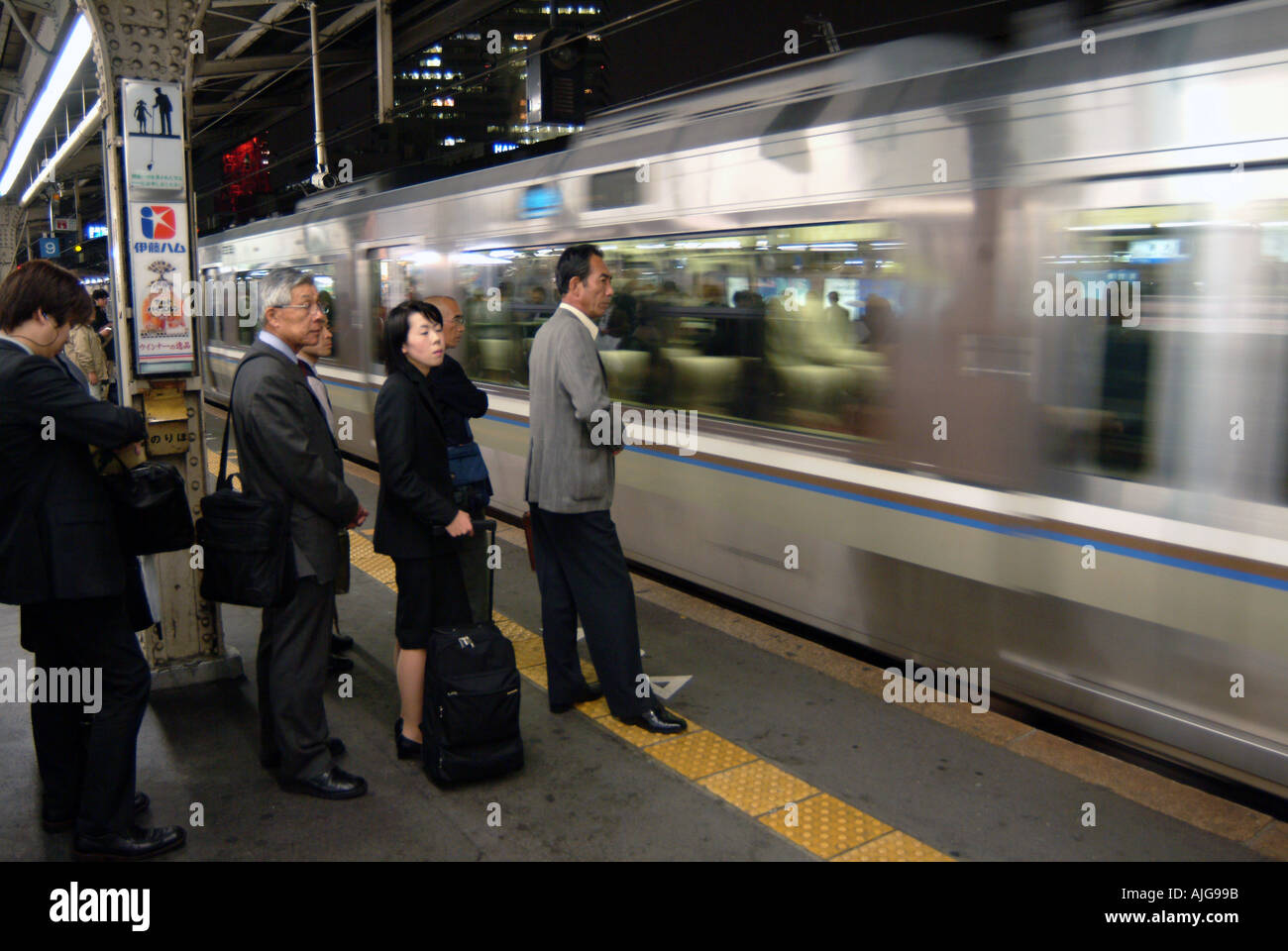 People waiting in a queue on a railway platform Osaka Japan Stock Photo ...