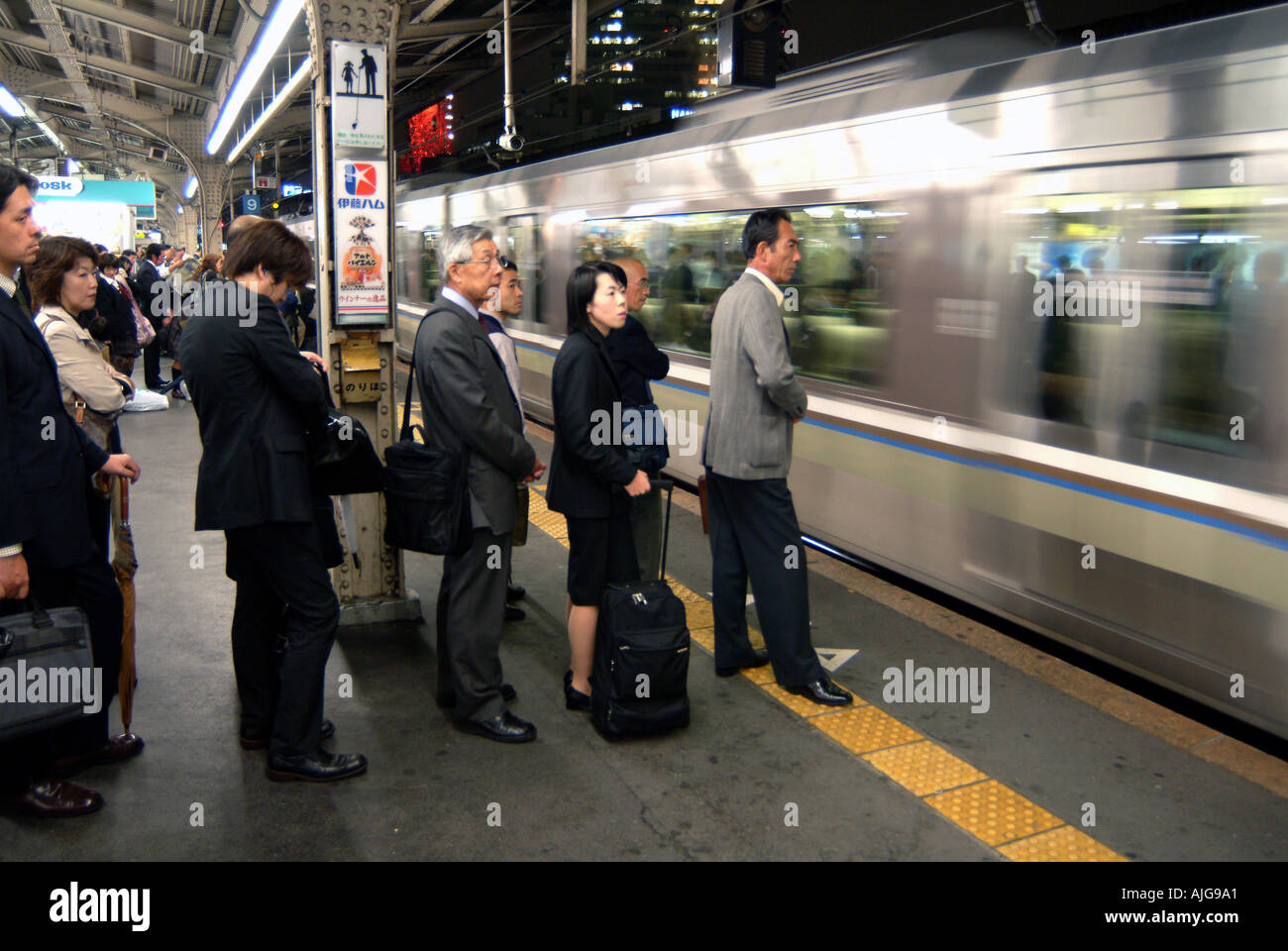 People waiting in a queue on a railway platform Osaka Japan Stock Photo ...