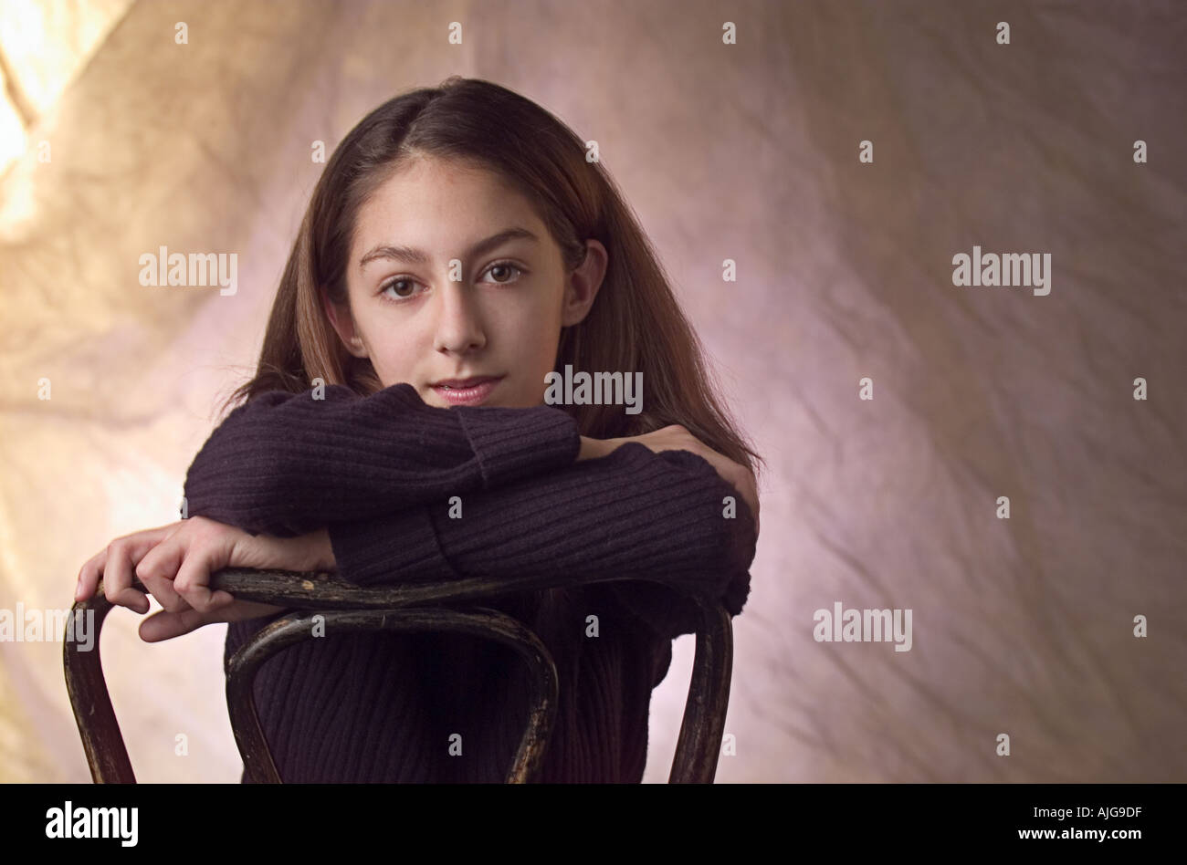 Teenage girl leaning on back of chair Stock Photo - Alamy