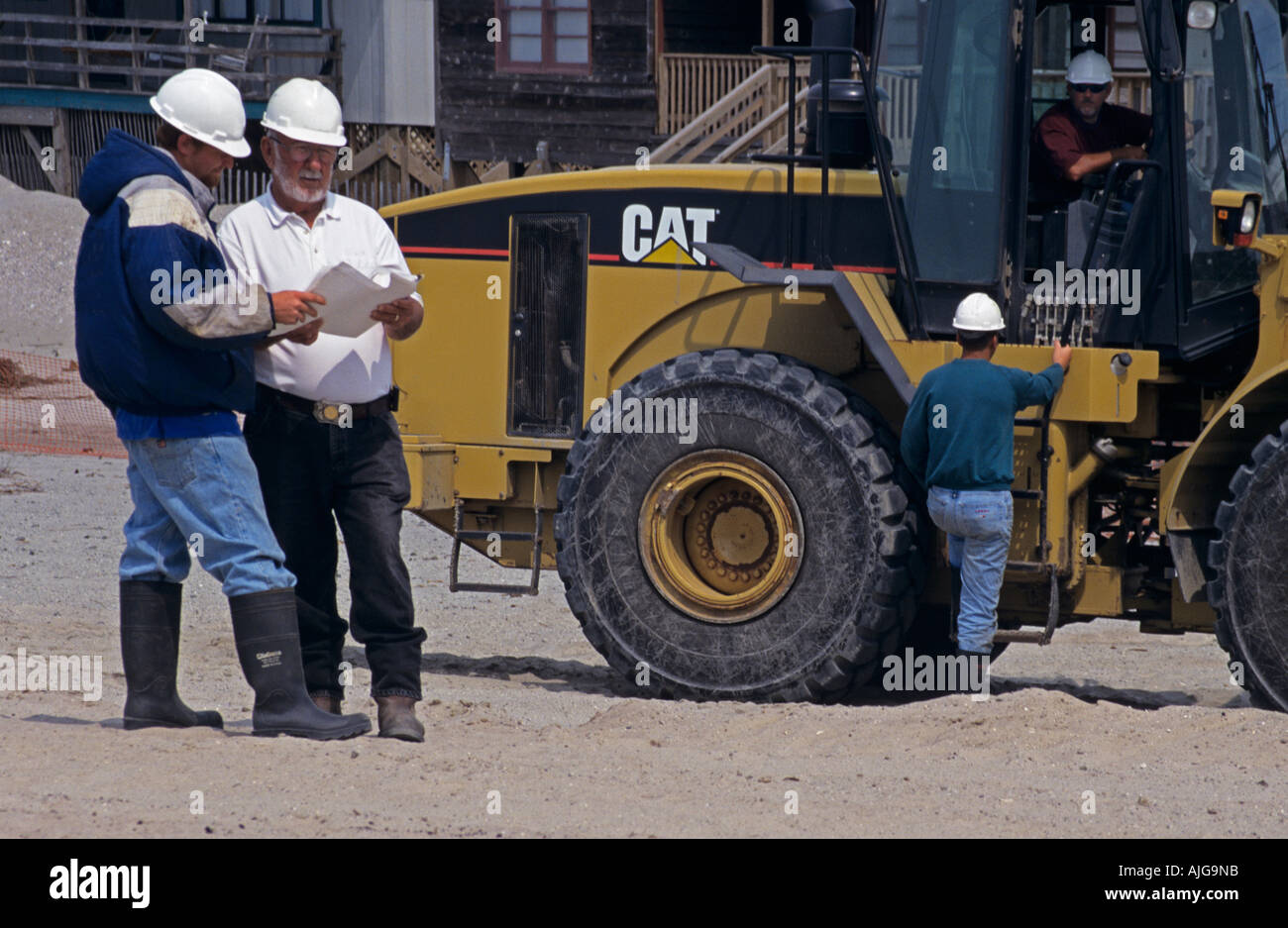 Surveyor and project manager on site with construction crew on building ...
