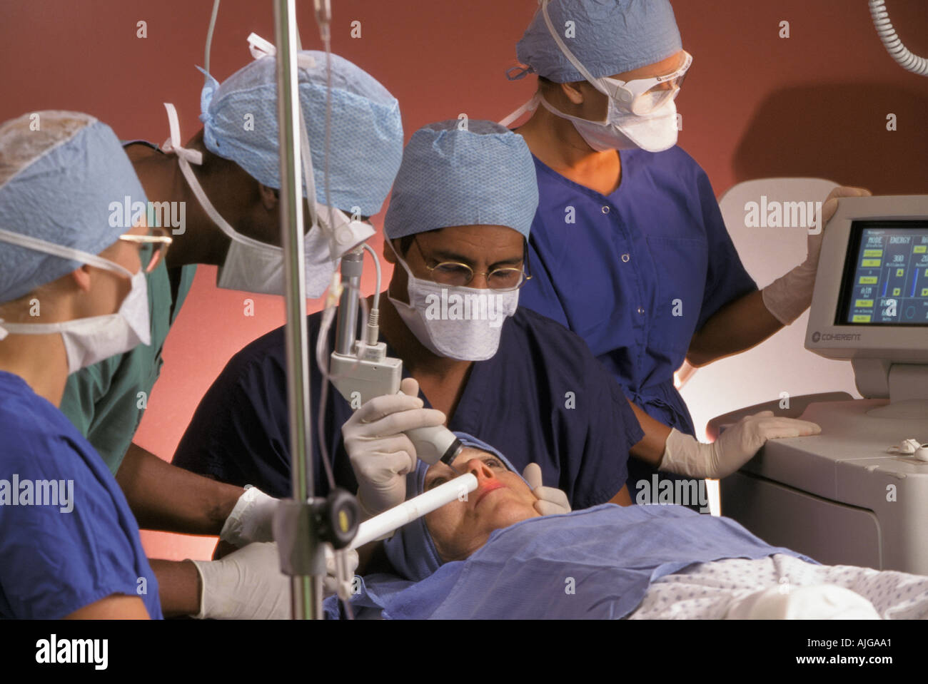African American and Caucasian medical team perform cosmetic surgical ...