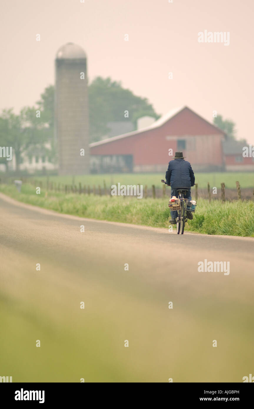 Amish man riding a bike along a country road near Arthur Illinois Stock ...