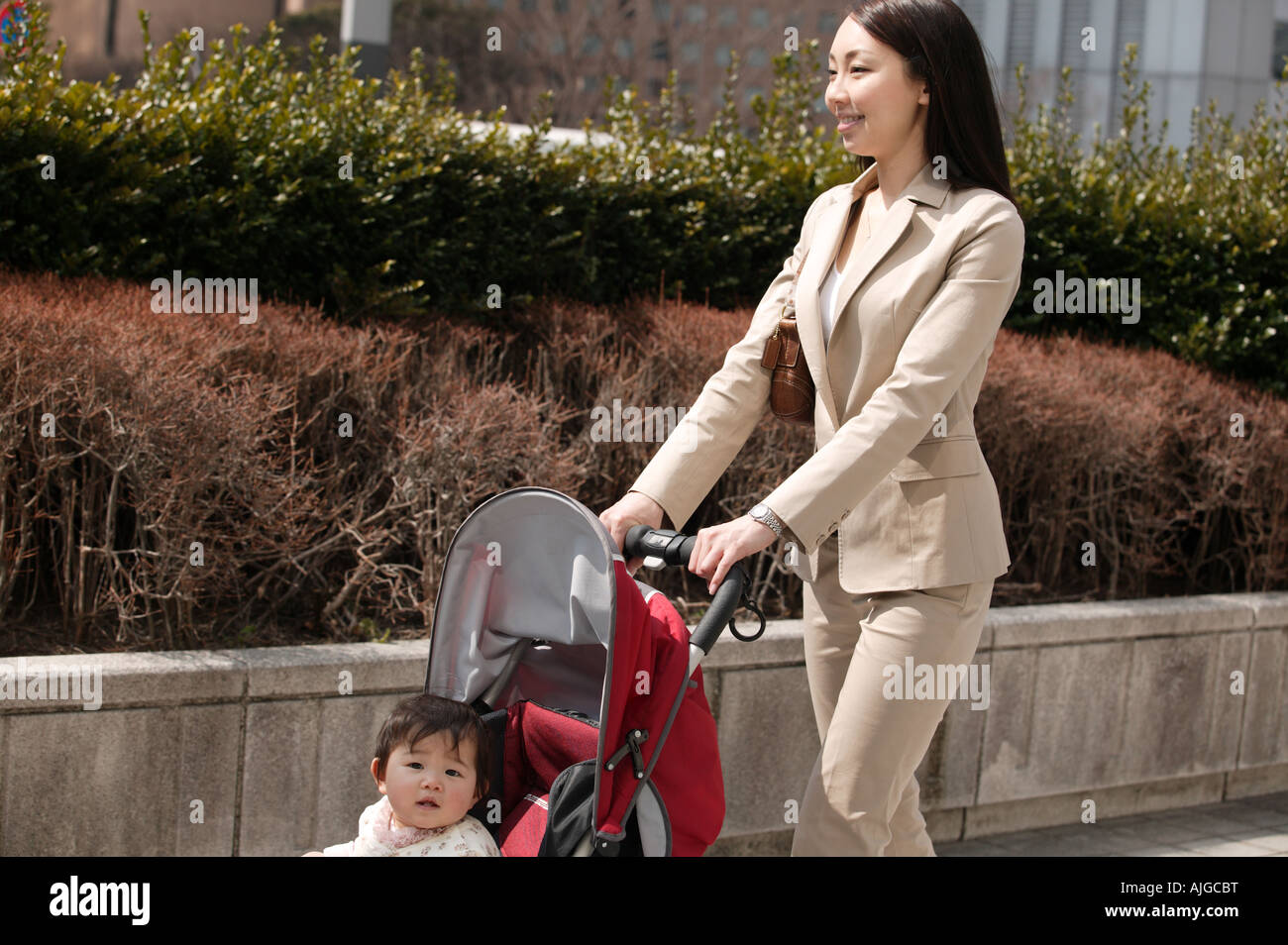 Woman pushing baby stroller hi-res stock photography and images - Alamy