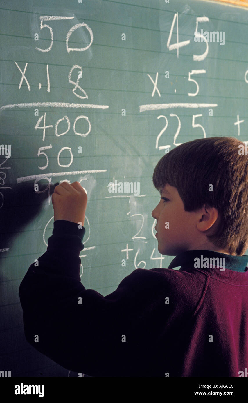 Caucasian Student writing math equations on a blackboard during math ...