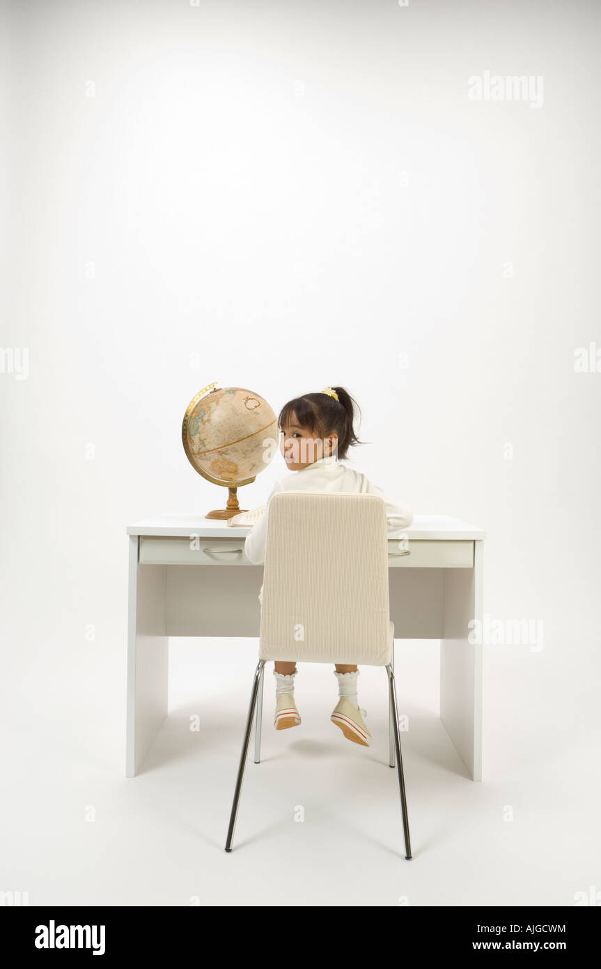 Elementary age girl sitting at desk Stock Photo - Alamy