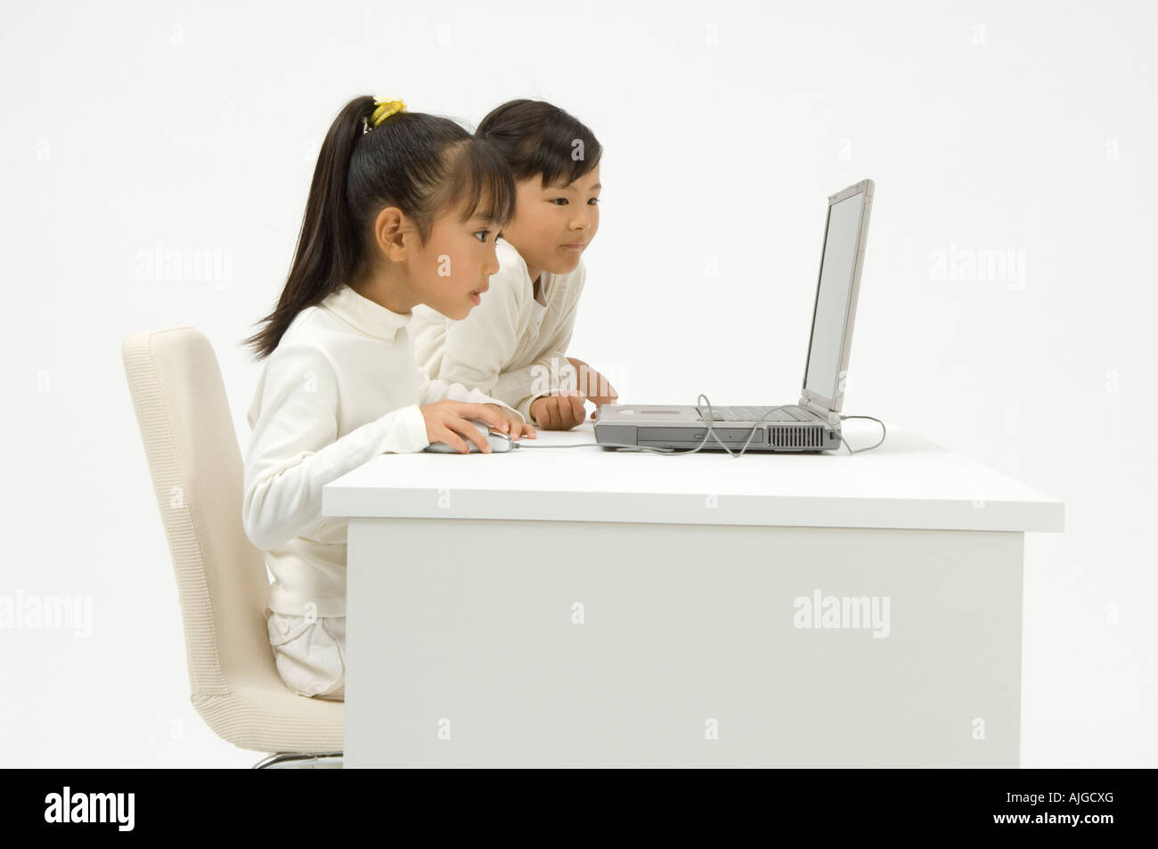 Two elementary age girls using laptop Stock Photo - Alamy