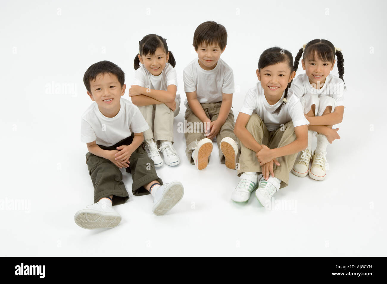 Five elementary age children sitting Stock Photo - Alamy
