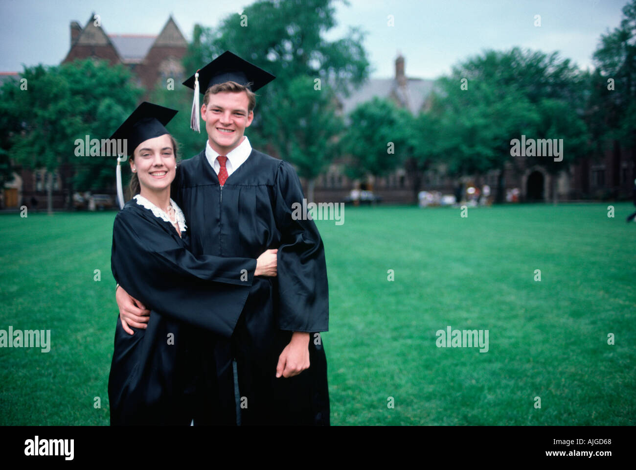 Portrait of a Caucasian male and female graduates embracing during ...