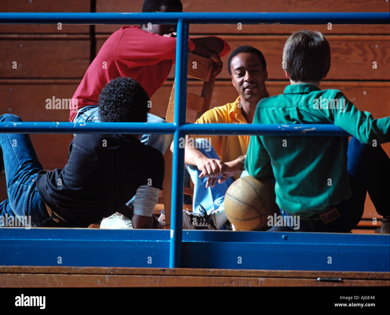 African American physical fitness coach mentoring students in gym after ...