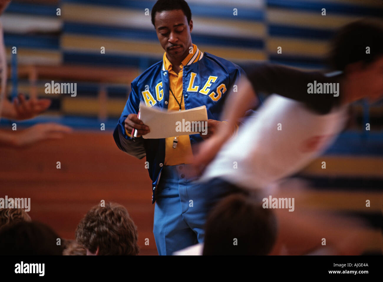 African American coach at work in a gymnasium teaching of physical ...