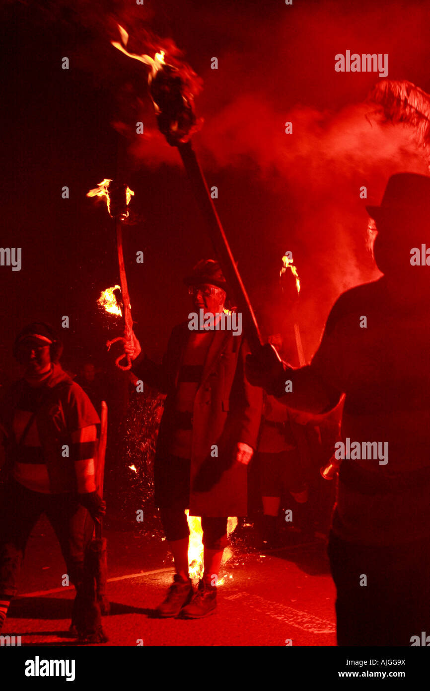Torch bearers in costume with red smoke in procession through ...